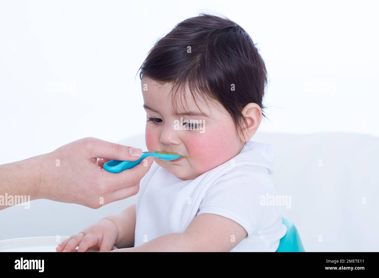 Baby girl (40 weeks) being fed with spoon Stock Photo - Alamy