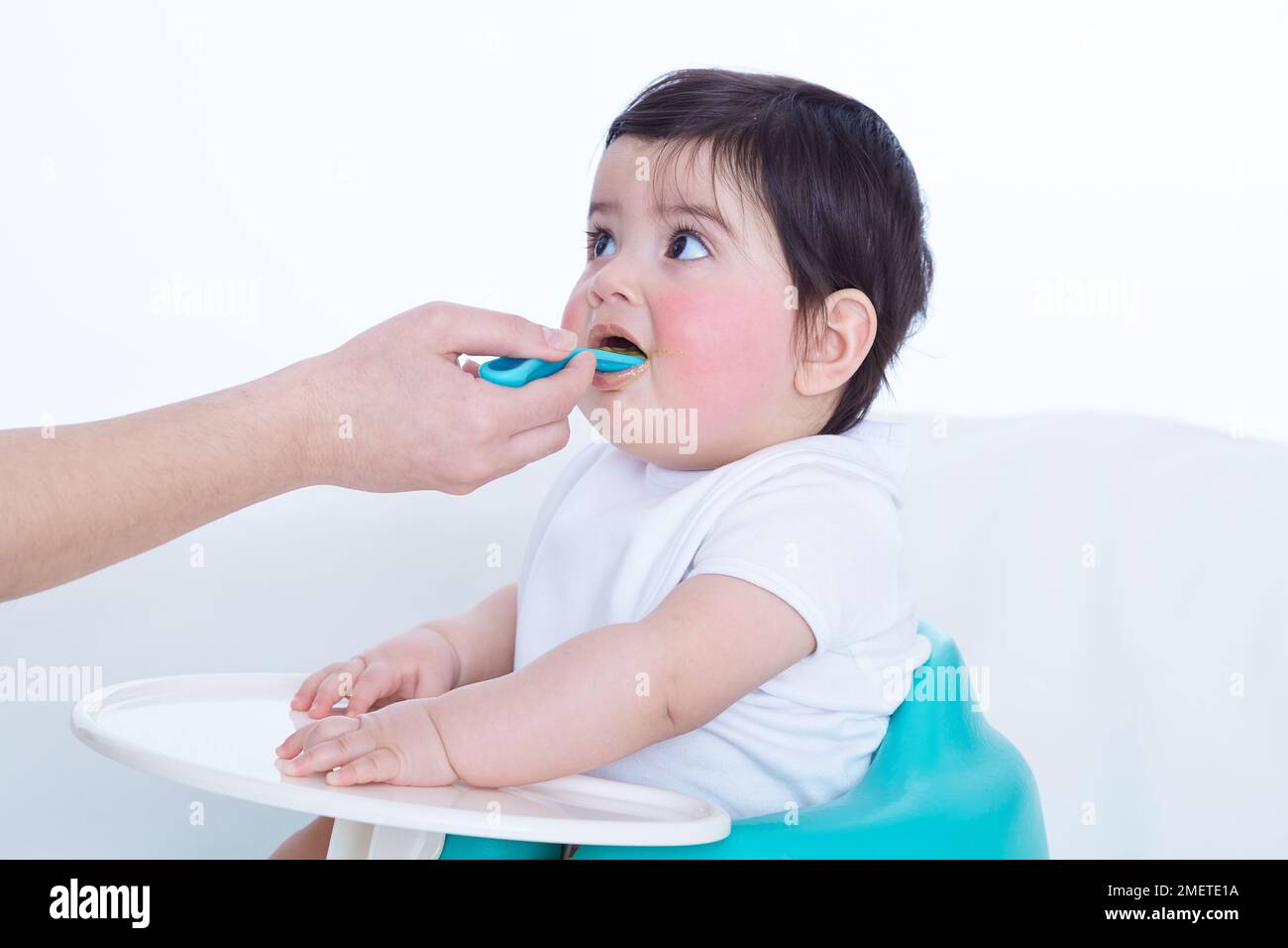 Baby girl (40 weeks) being fed with spoon Stock Photo - Alamy