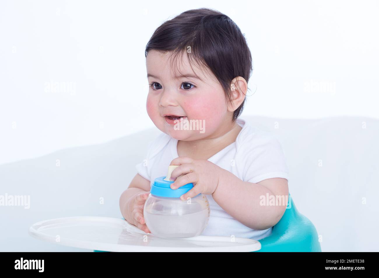Baby girl (40 weeks) holding plastic drinking cup Stock Photo - Alamy