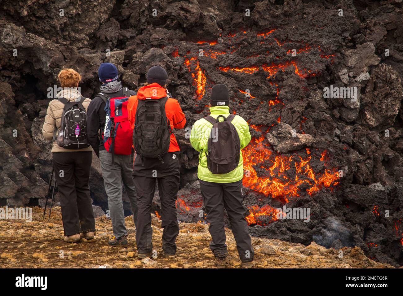 People watch the Lava flows from an eruption of a volcano on the ...