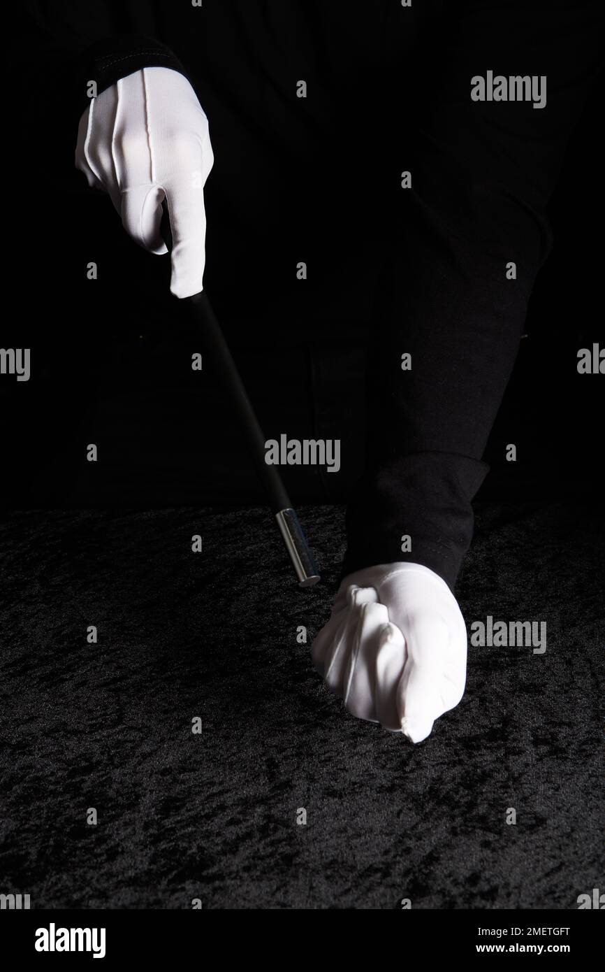 Magician performing trick using wand Stock Photo - Alamy