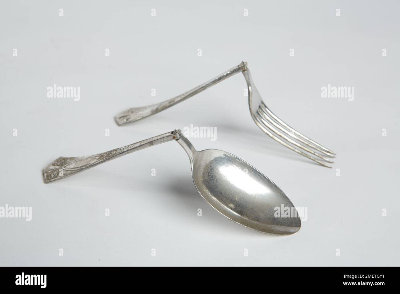 Twisted spoon and fork trick Stock Photo - Alamy