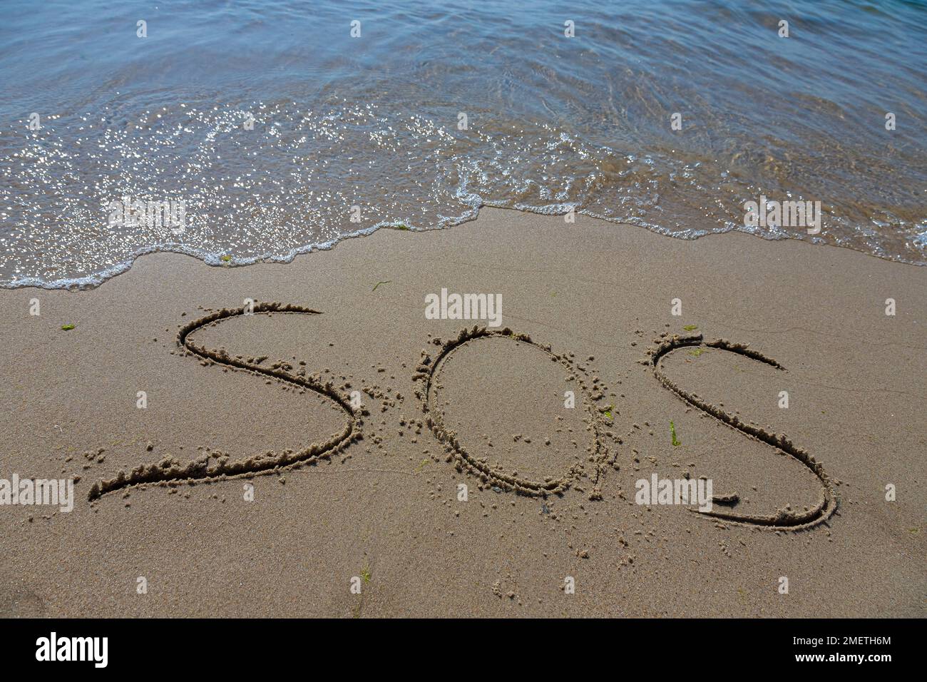 The inscription on the sand at the beach sos Stock Photo - Alamy