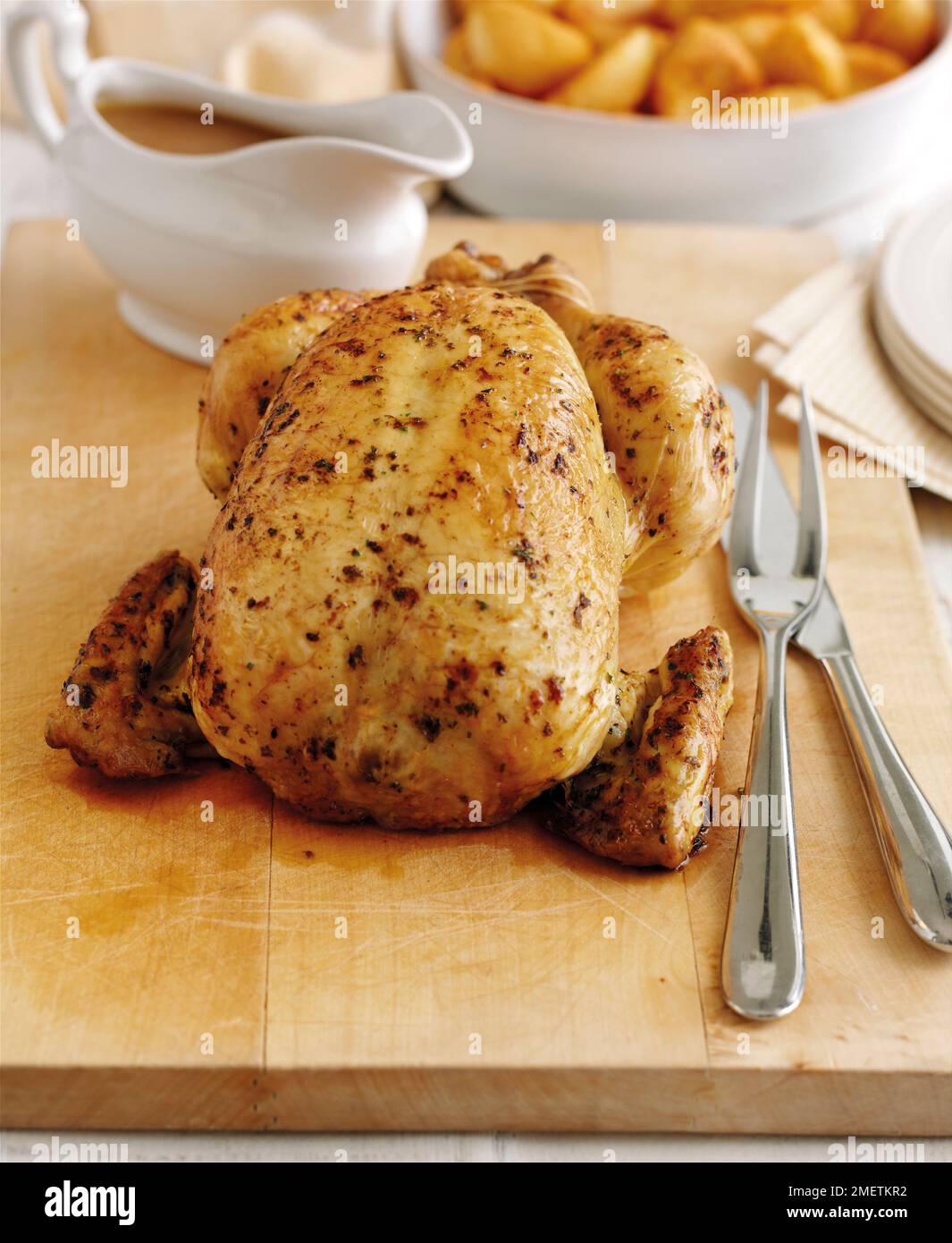 Roast chicken basted in herb butter, gravy boat in background Stock ...