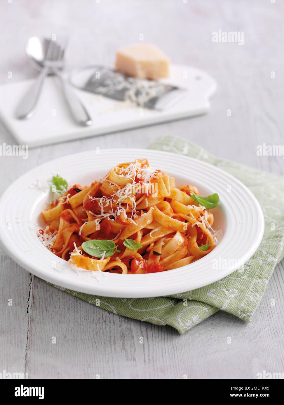 Tagliatelle pasta with tomato sauce, grated cheese and fresh basil ...
