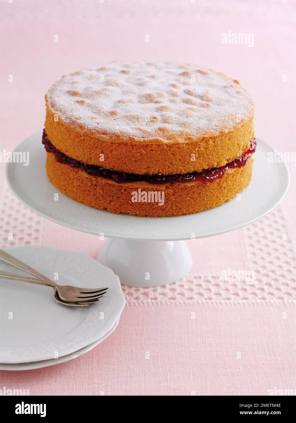 Victoria sandwich cake filled with jam and dusted with icing sugar, on ...