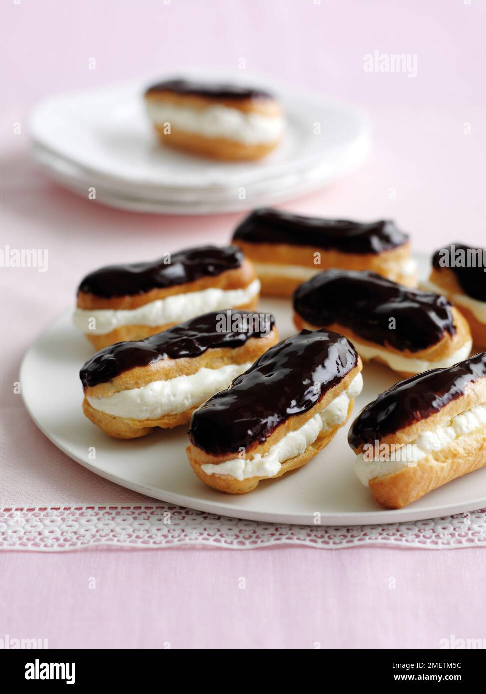Eclairs with chocolate icing and whipped cream filling Stock Photo - Alamy