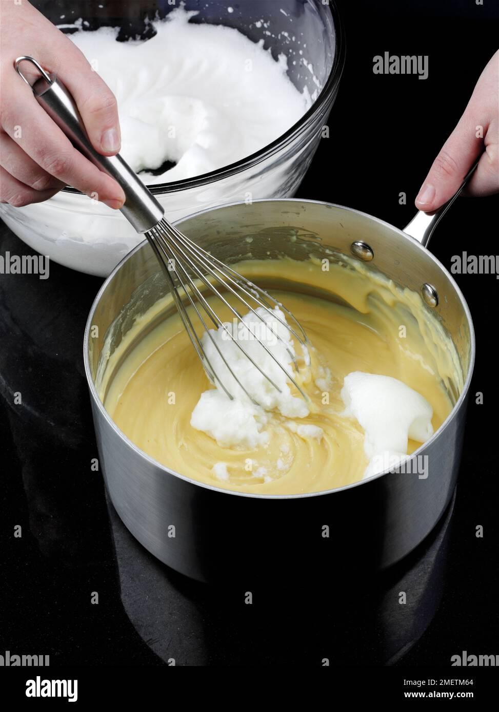 Making cheese souffles, adding egg whites to cooled sauce and beating ...