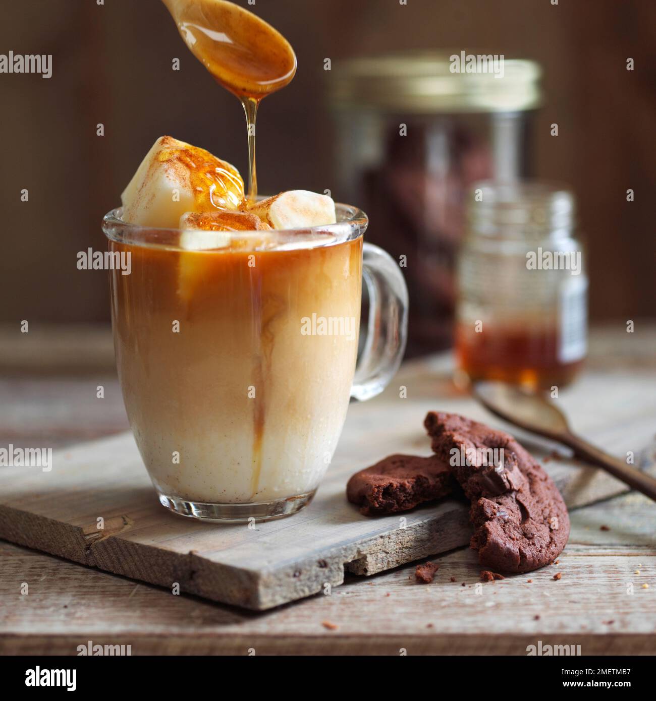 Milk and Honey, adding spoon of honey to coffee, milk and milk cubes in ...