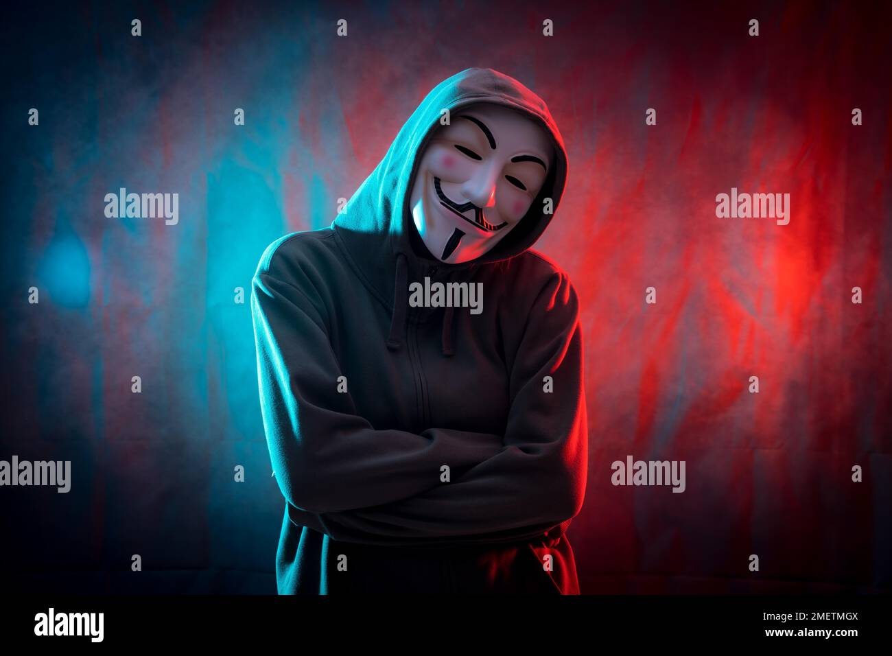 Hacker with anonymous mask with arms crossed, red and blue background ...