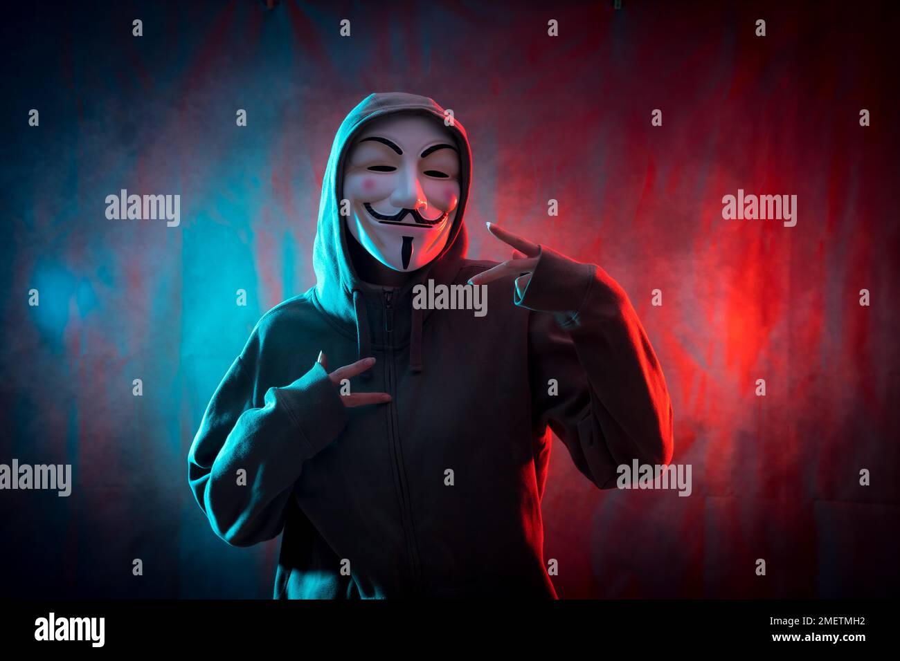 Hacker with anonymous mask making the victory symbol, red and blue ...