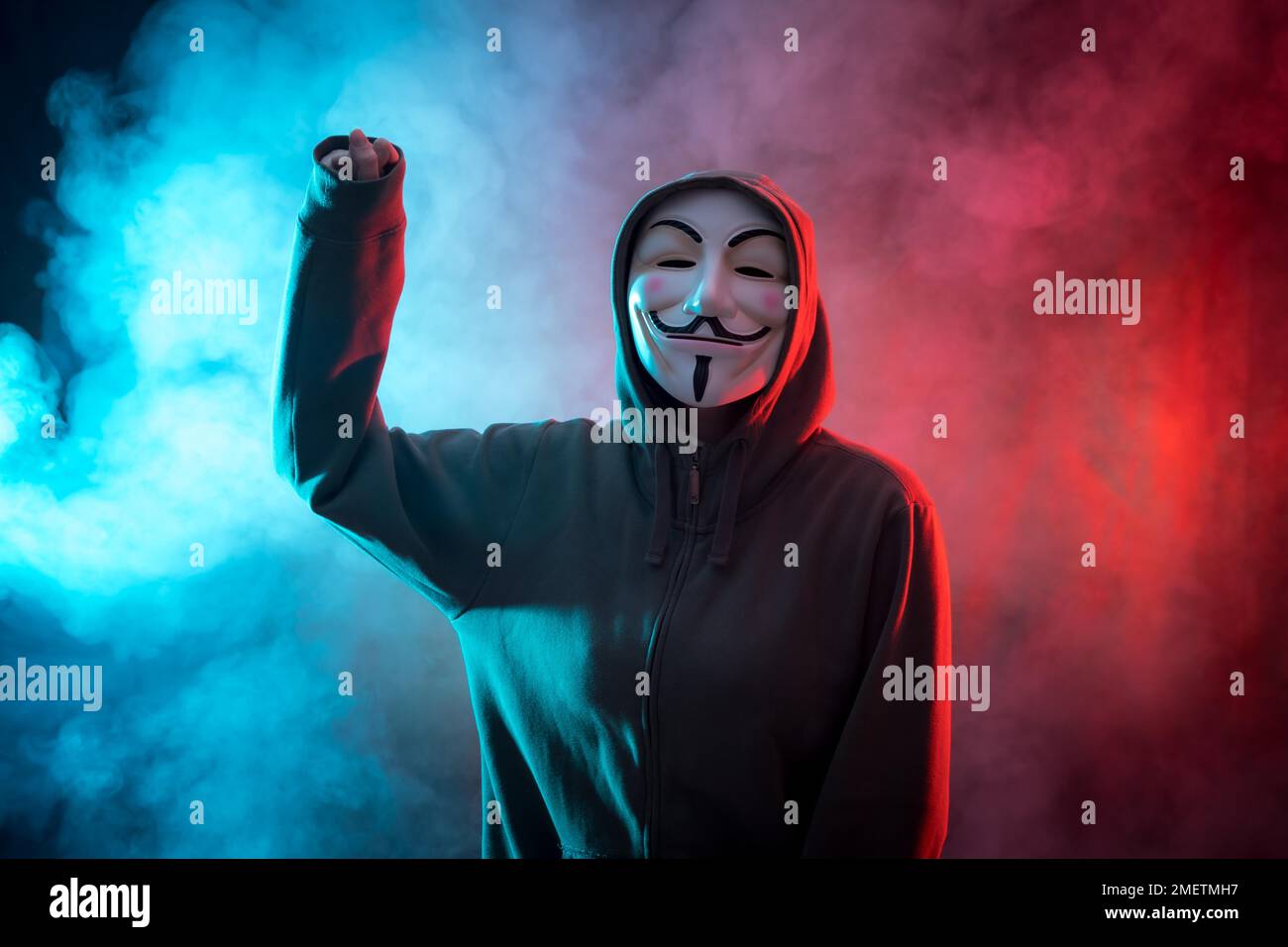 Hacker with anonymous mask with his fist raised in symbol of fight, red ...