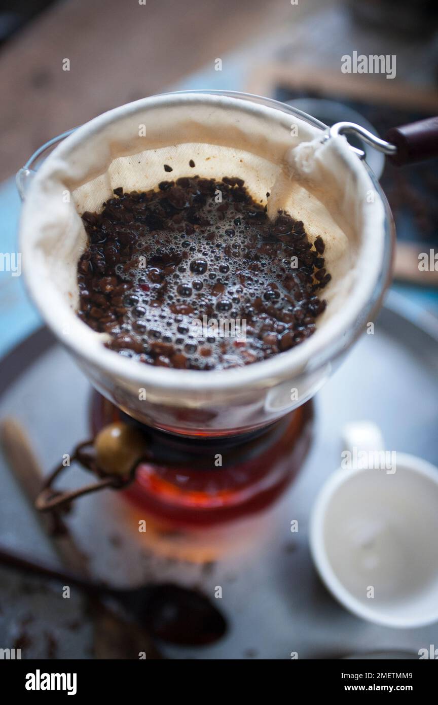 Caffe Touba, coffee draining through a cloth into glass jug Stock Photo ...
