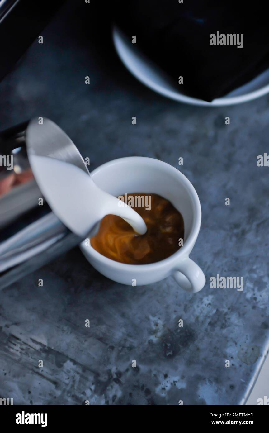 Pouring steamed milk on cup of coffee, step 11 Stock Photo - Alamy