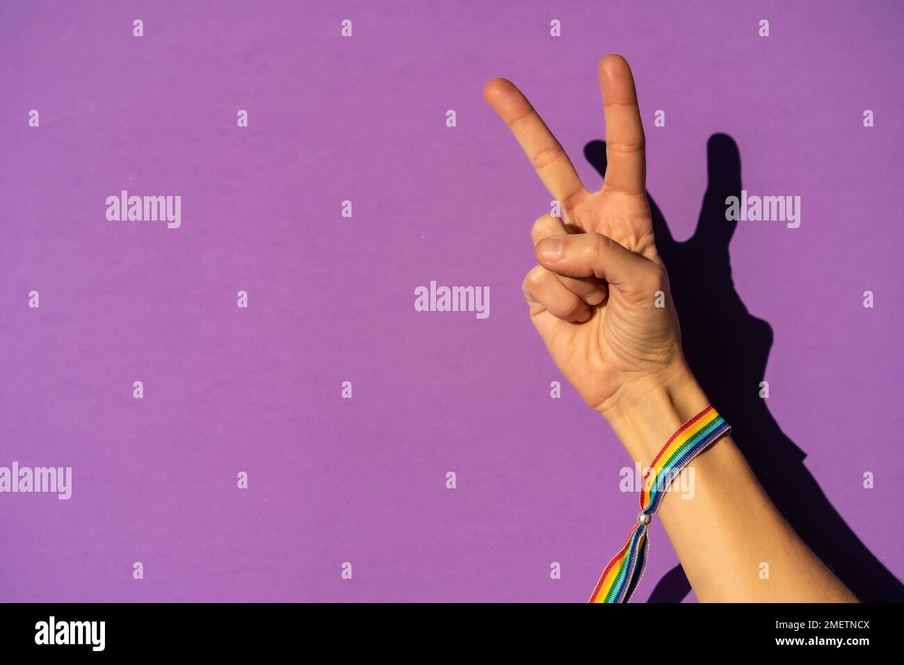 Hand of a woman with victory symbol in favor of feminism, purple ...