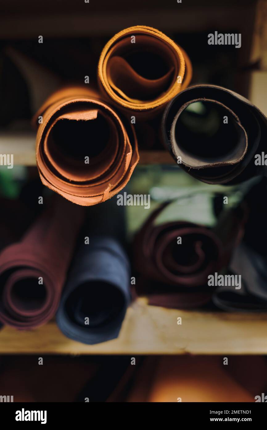 Rolls of cloth and leather lie on market shelves. Different fabric ...