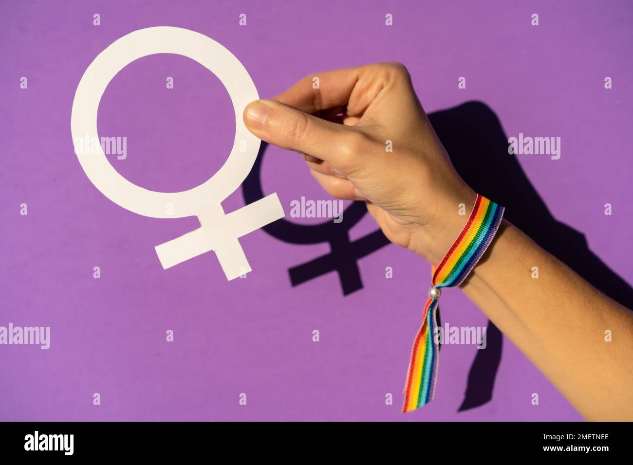 A woman holding a female symbol drawing, purple background, fighting in ...