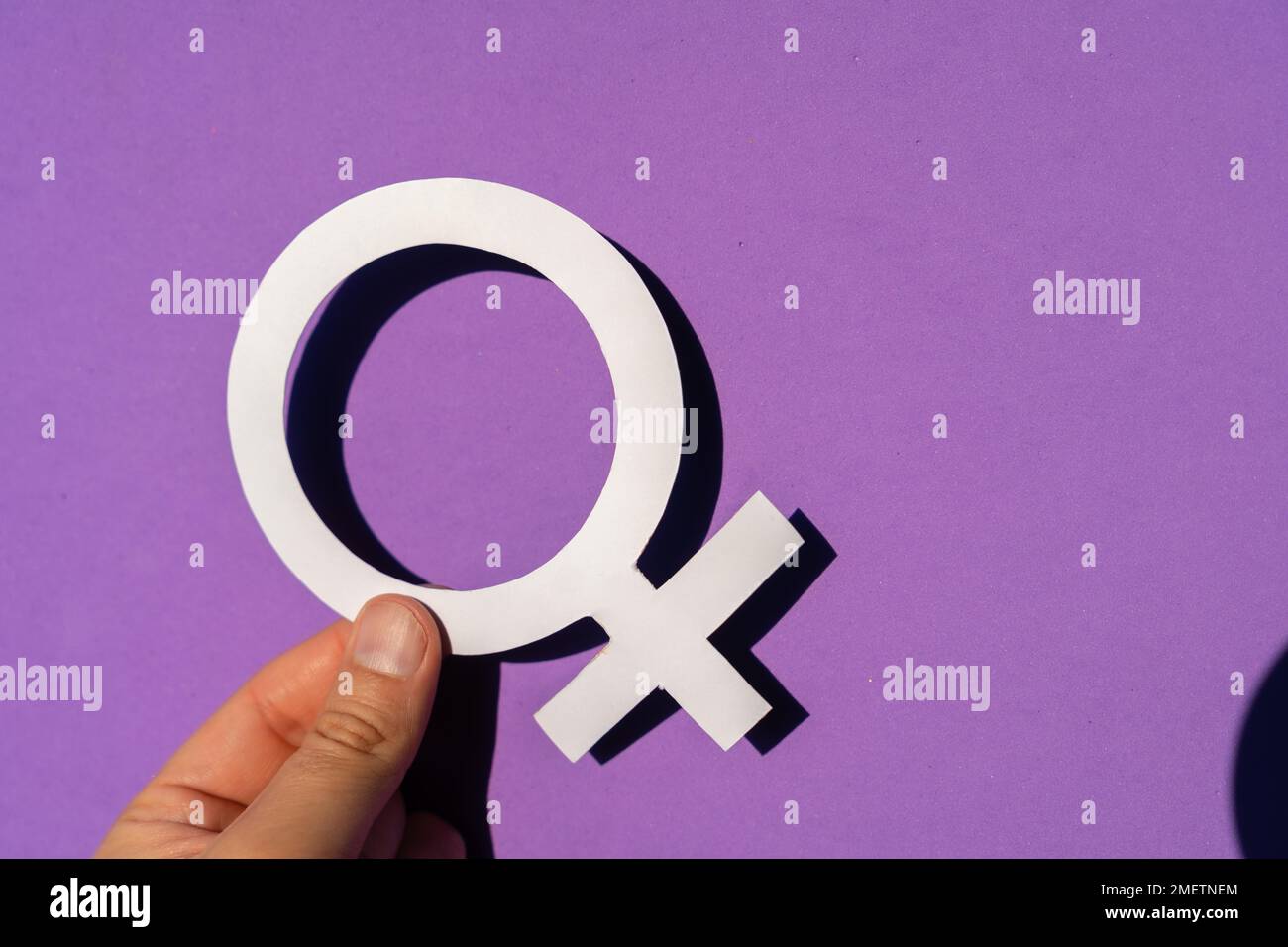 A woman holding the female symbol on a purple background, march for ...