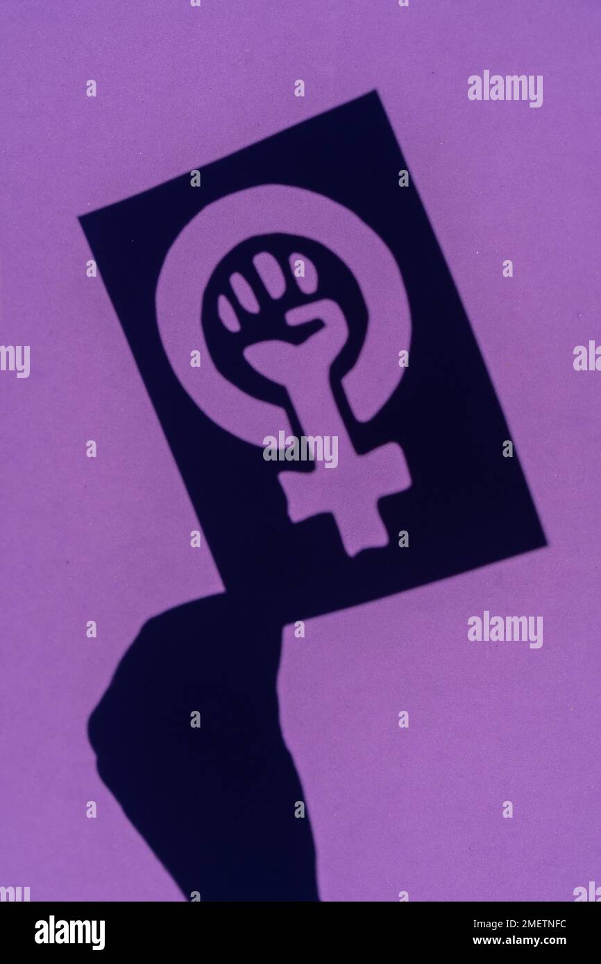 Shadow of the symbol of the fight for feminism on a purple background ...