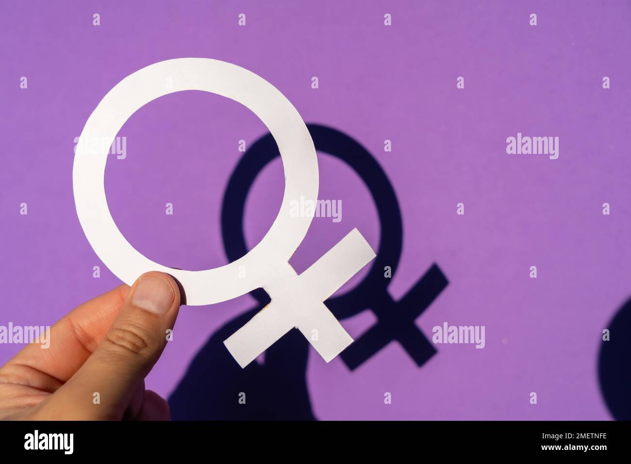 A woman holding the female symbol on a purple background, march for ...