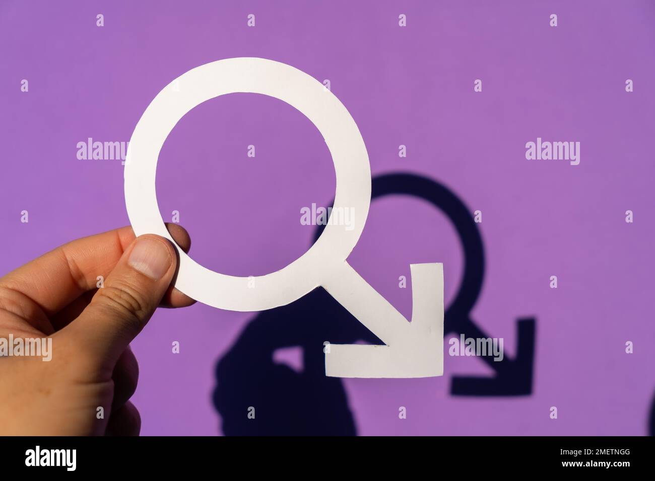 A man holding the male symbol on a purple background and his beautiful ...