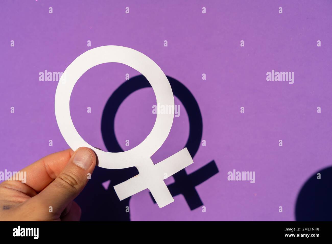 A woman holding the female symbol on a purple background, march for ...