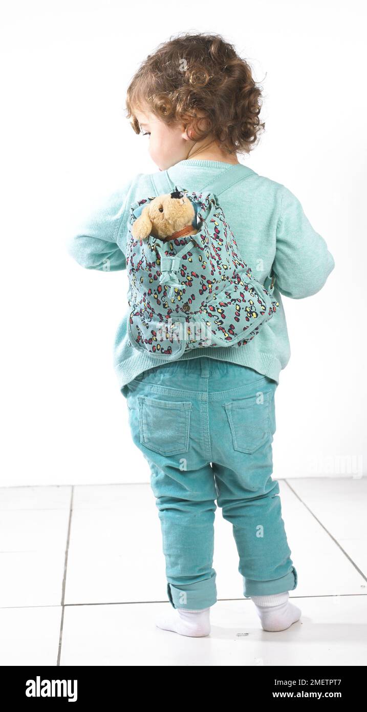 Small girl standing wearing backpack, 2 years Stock Photo - Alamy
