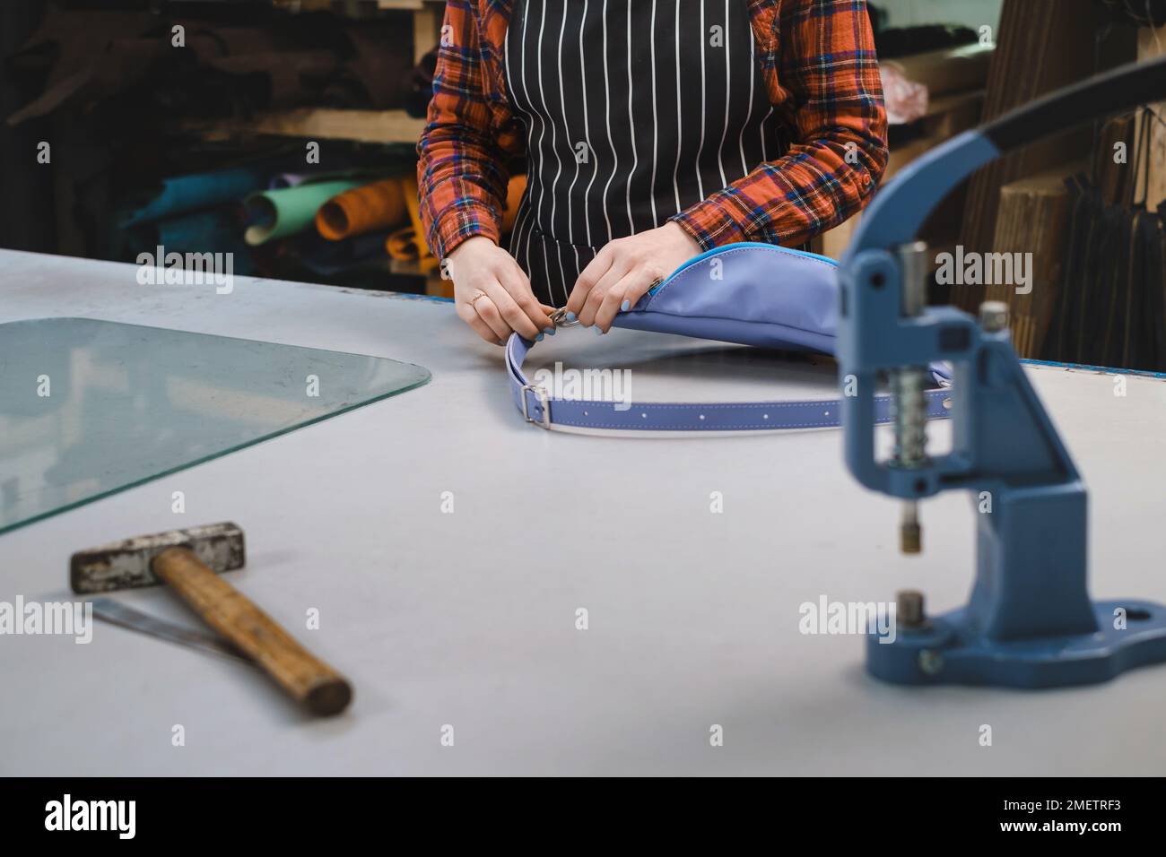 Sewing process. Tailor sewing bag at workshop. Woman creating accessories on workplace ...
