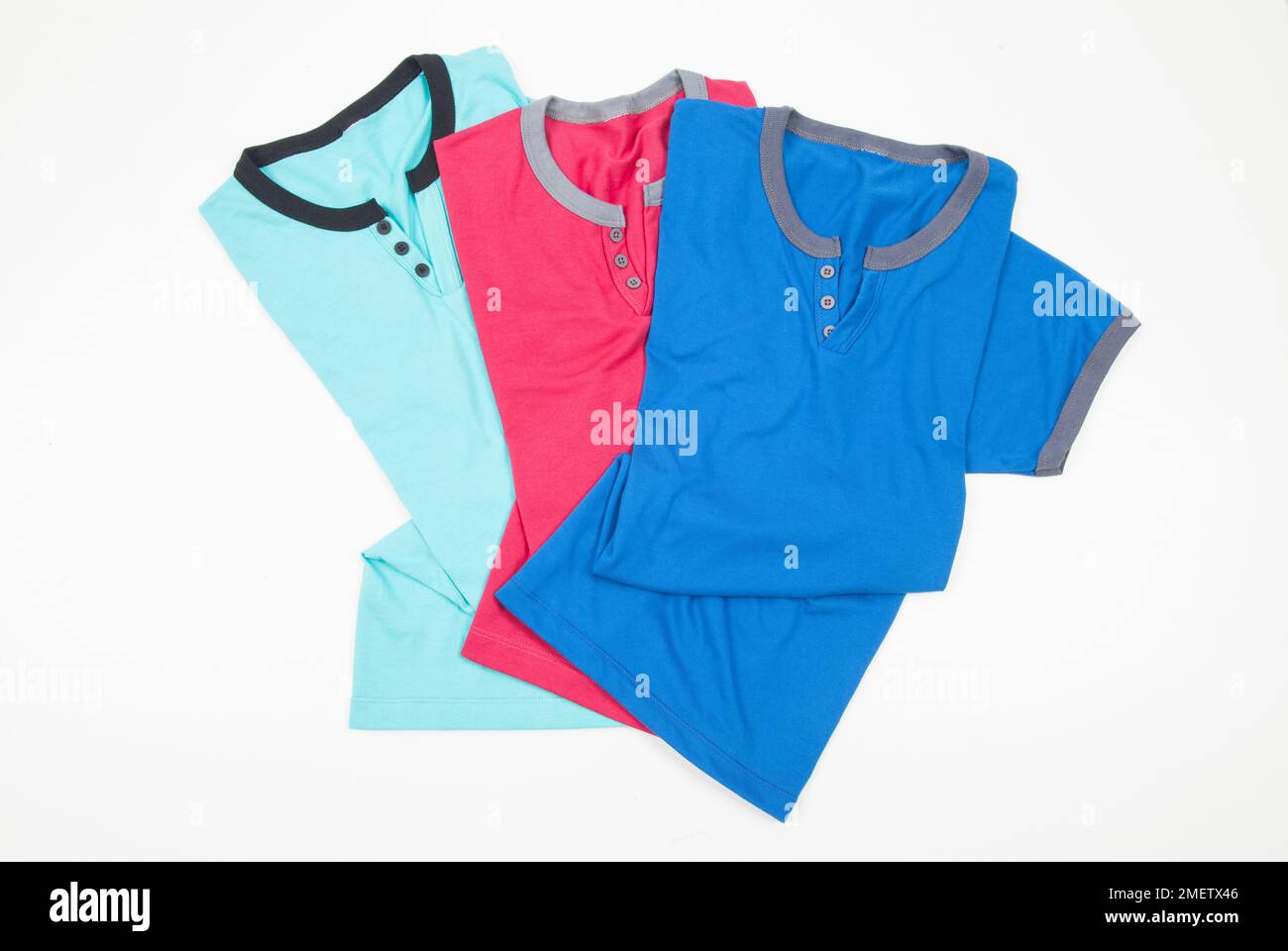 set of three different colored shirts for man bent on white background ...