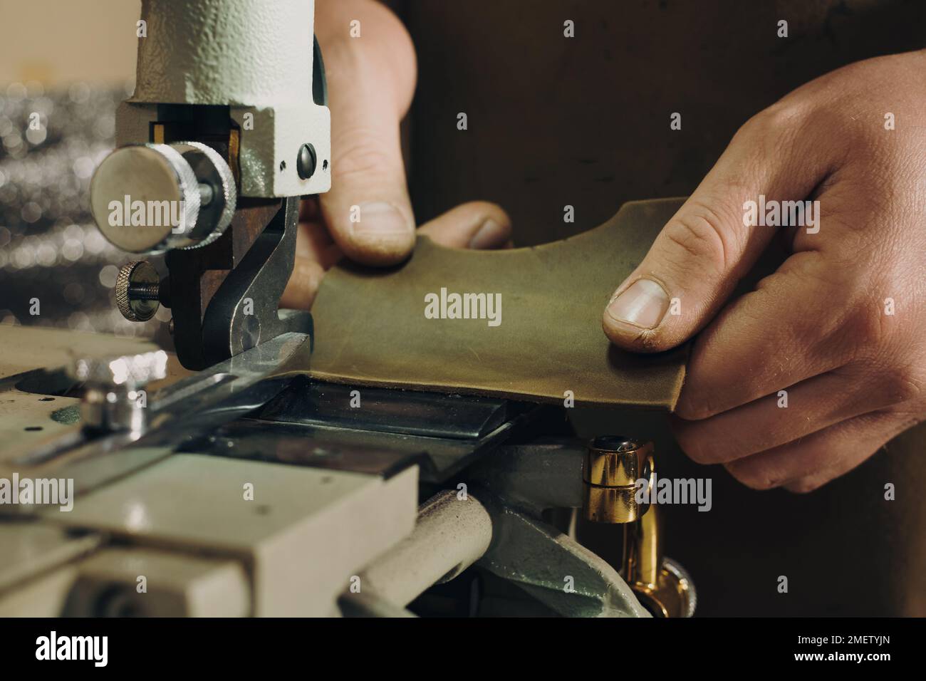 Machining leather in workshop. Cropped view of the man hands holding ...