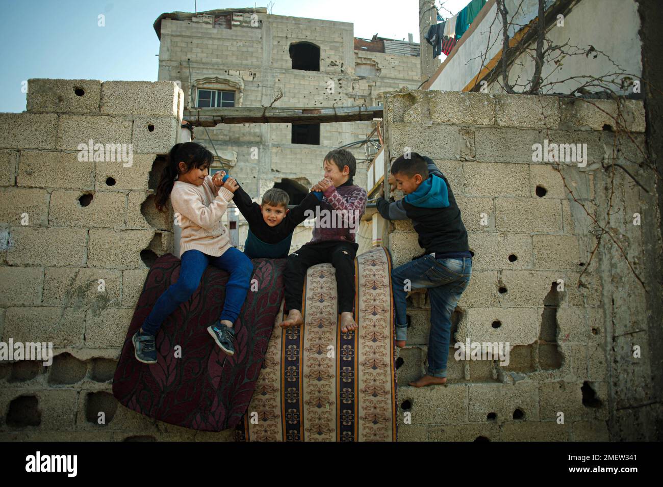 Palestinian children play outside their homes in a poor neighborhood in ...