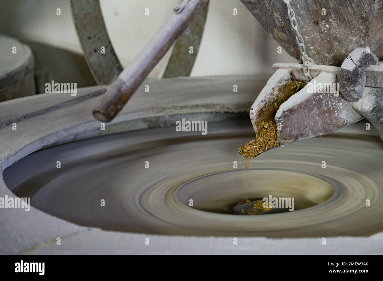Wheat falling onto water-driven grindstone at Molino Grifoni, mill ...