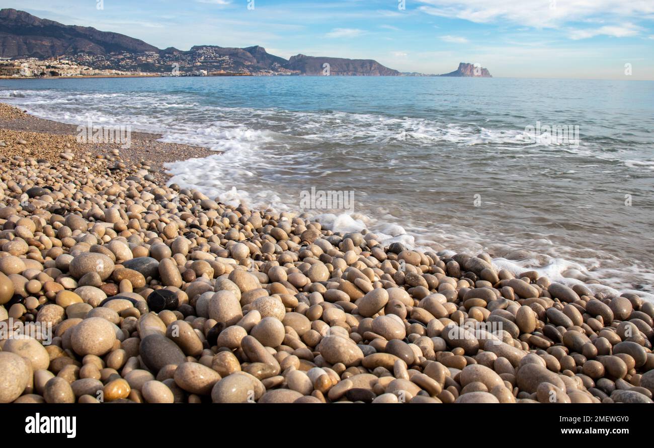 Alfaz del Pi beach with its stones in the foreground getting wet with ...