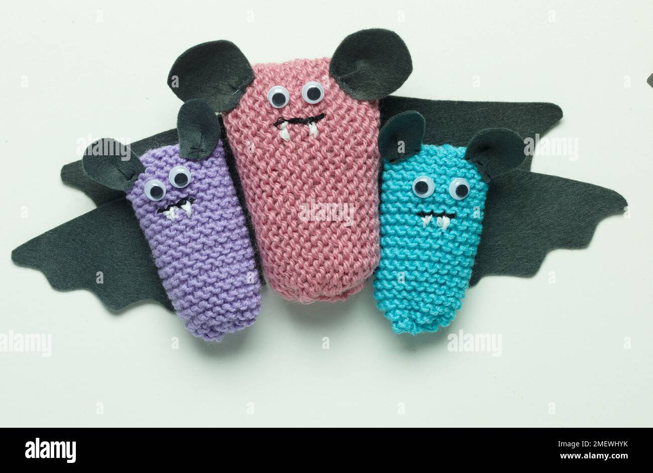 Large pink knitted bat, with smaller purple, and blue bat Stock Photo ...