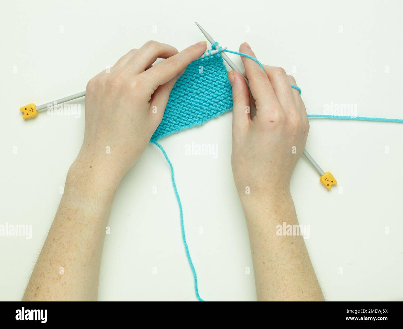 Casting off knitting by lifting one loop over another Stock Photo - Alamy