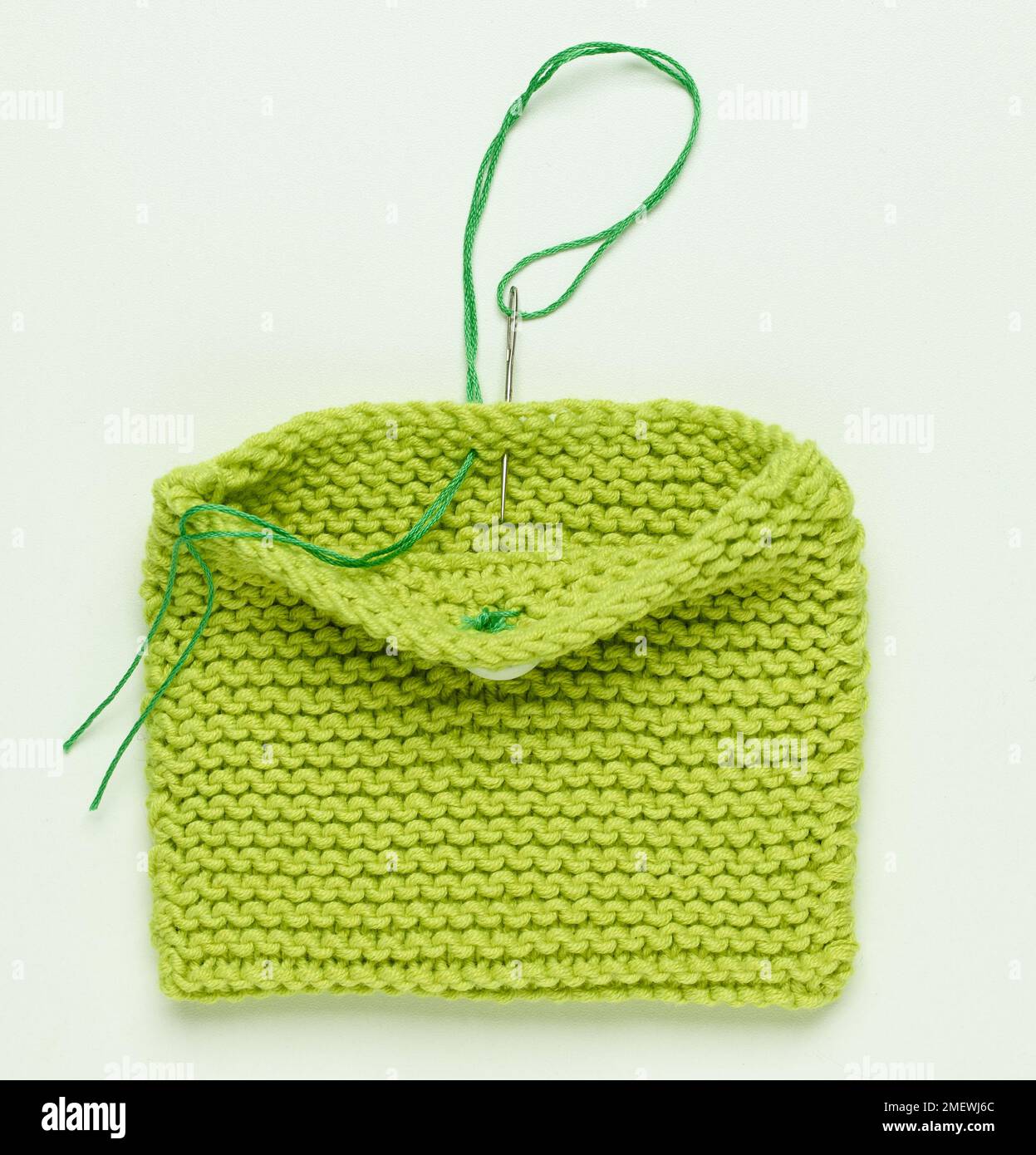 Steps for making knitted bag in green yarn, with button fastening, long ...