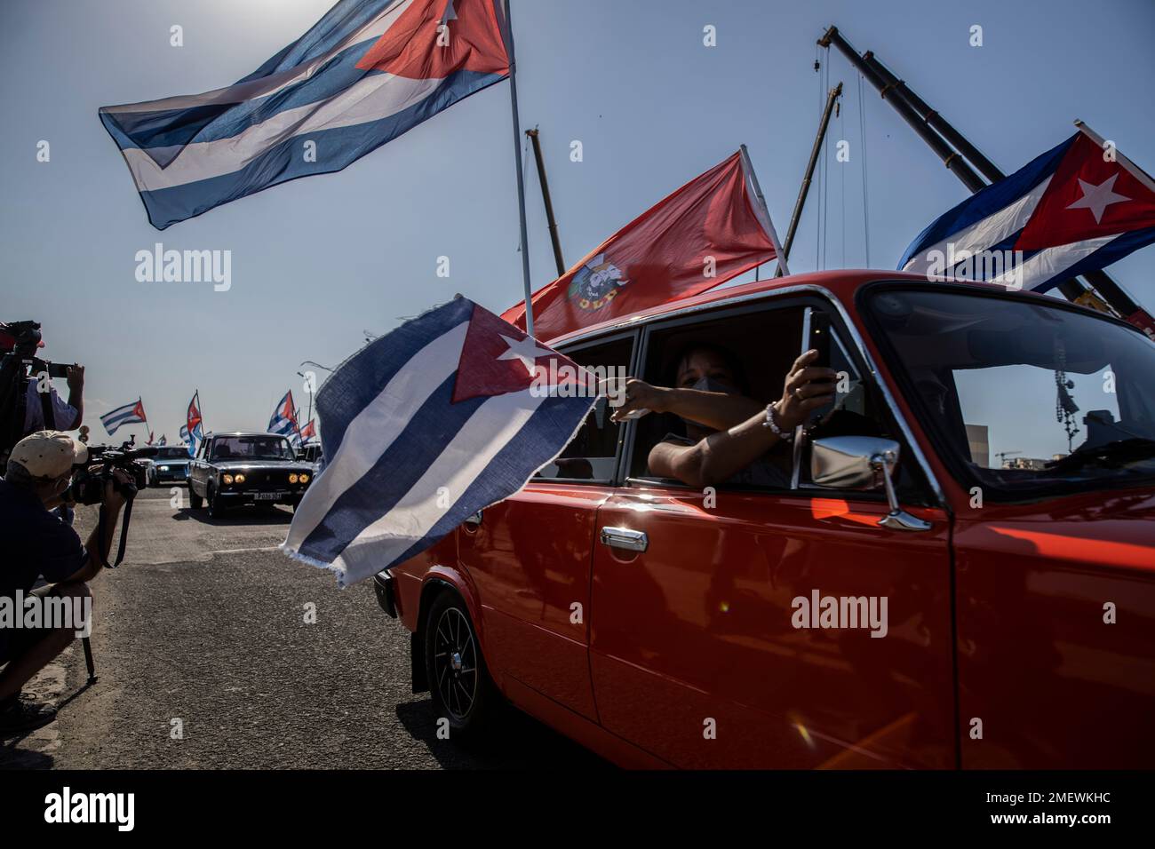 Soviet-era Lada cars flying Cuban flag drive past the American embassy ...