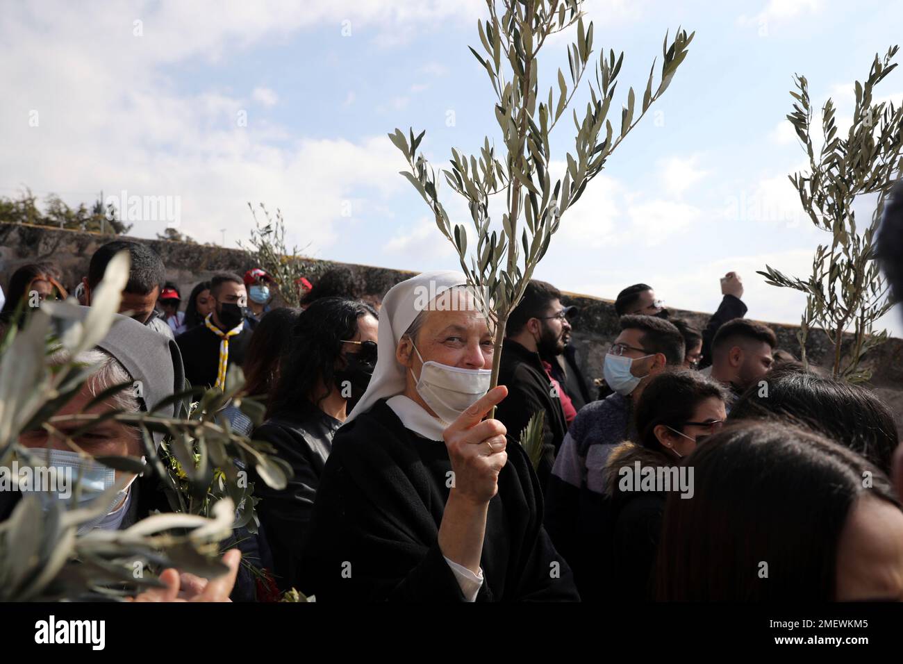 A nun holds an olive branch during a Palm Sunday procession on the ...