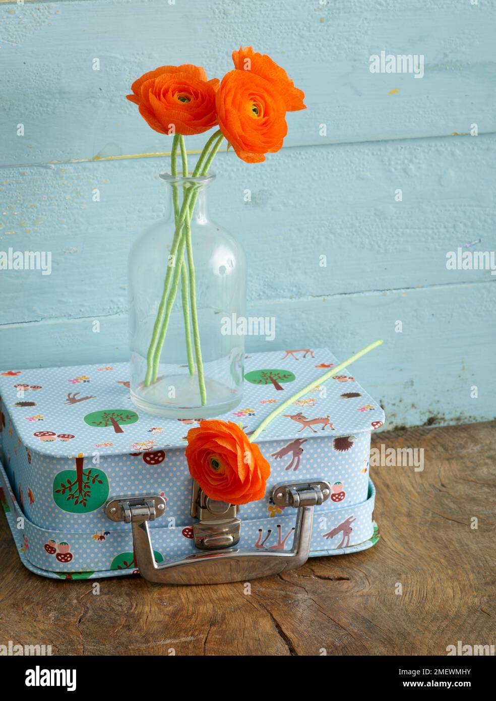 Papercraft. DIY Paper Ranunculus in glass bottle on suitcase with blue ...
