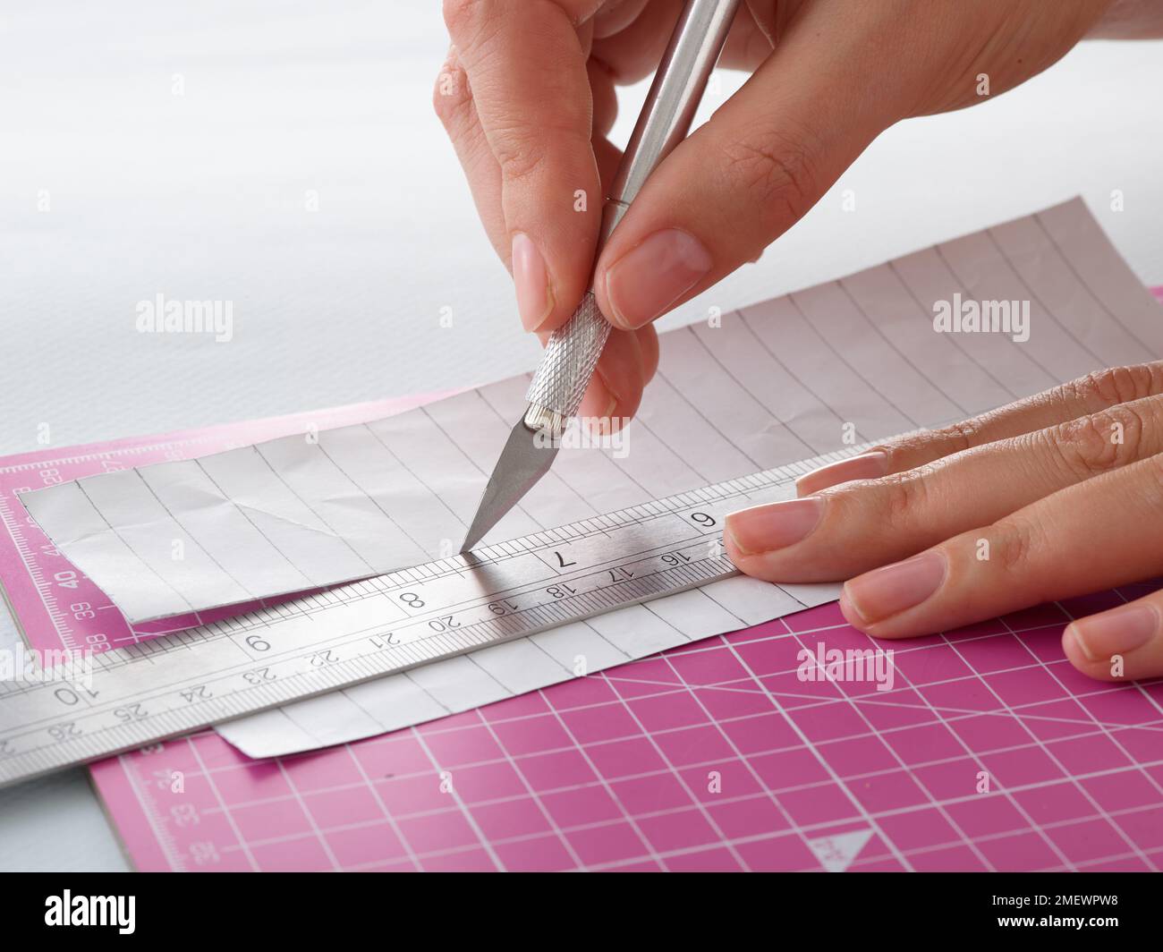 Papercraft. DIY accordian fold step 2. Cutting paper in two Stock Photo ...