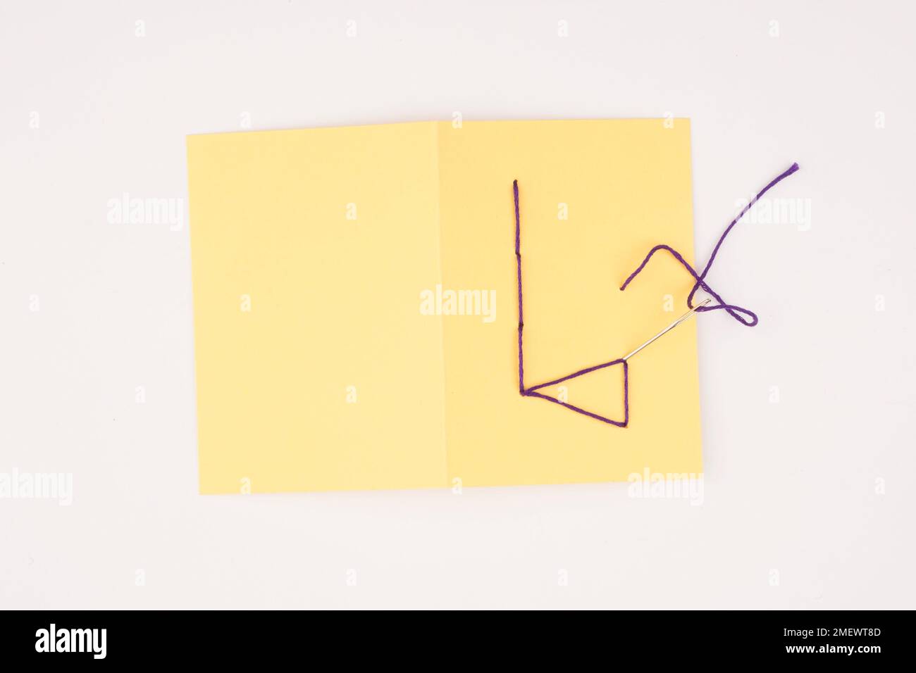 Sewing a design onto card with a needle and thread Stock Photo - Alamy