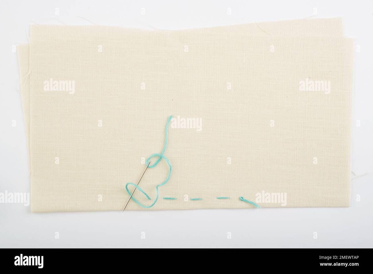 Knotting the thread to finish off running stitch Stock Photo - Alamy