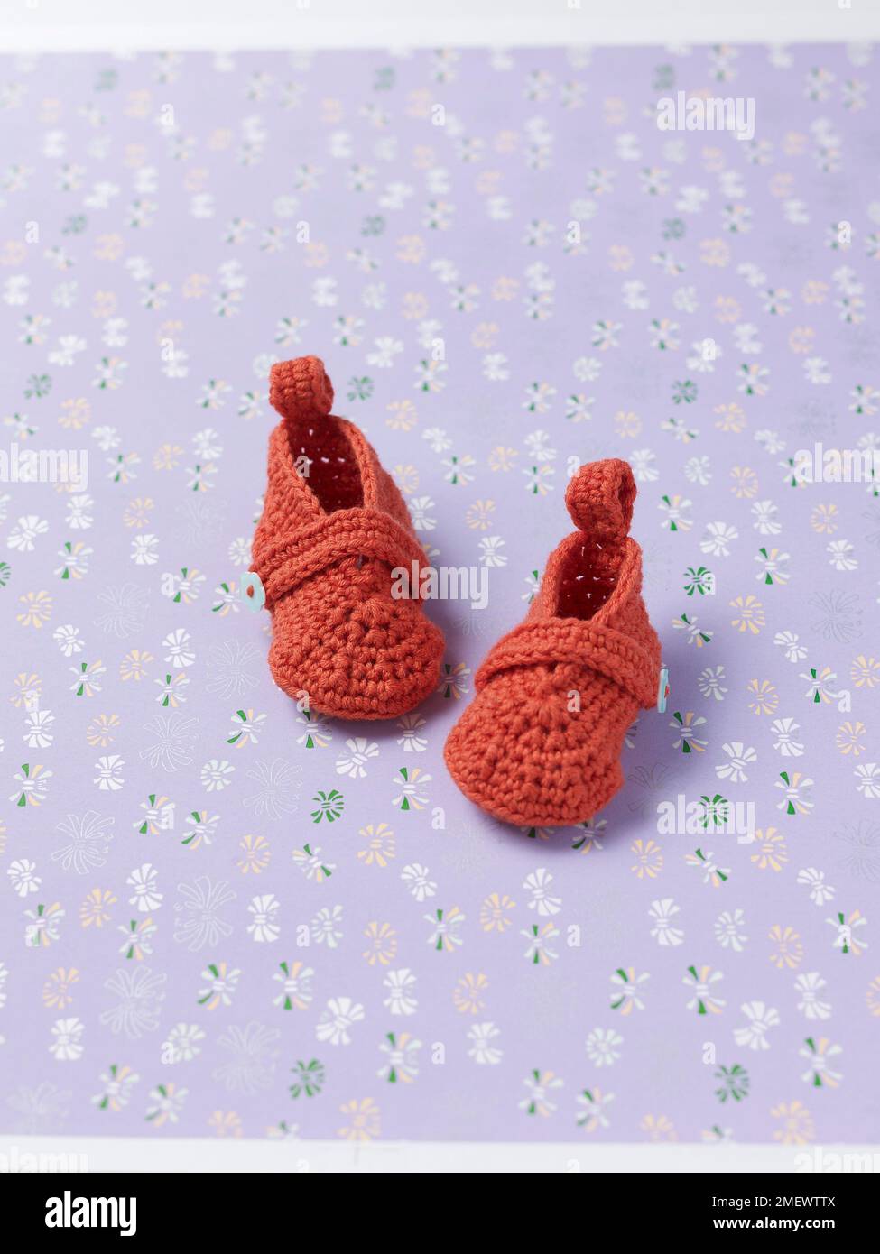 Crochet booties on patterned paper Stock Photo - Alamy