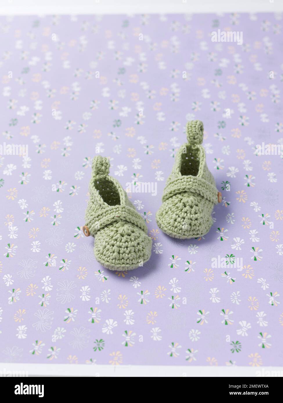 Crochet booties on patterned paper Stock Photo - Alamy