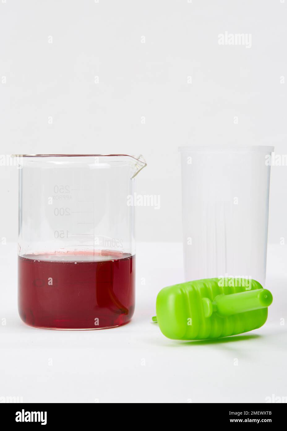 Melted ice lolly liquid in a glass flask next to ice lolly mould Stock ...