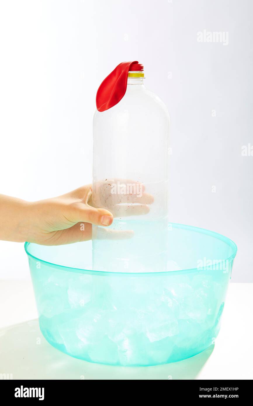 Plastic bottle with red balloon over the top, sitting inside a ...