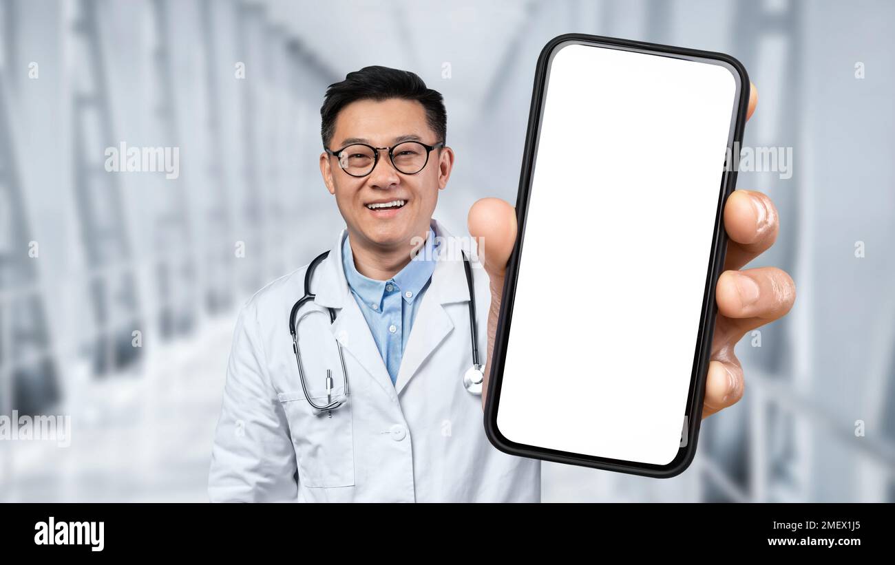Happy Asian Doctor Holding Big Blank Smartphone With White Screen In ...