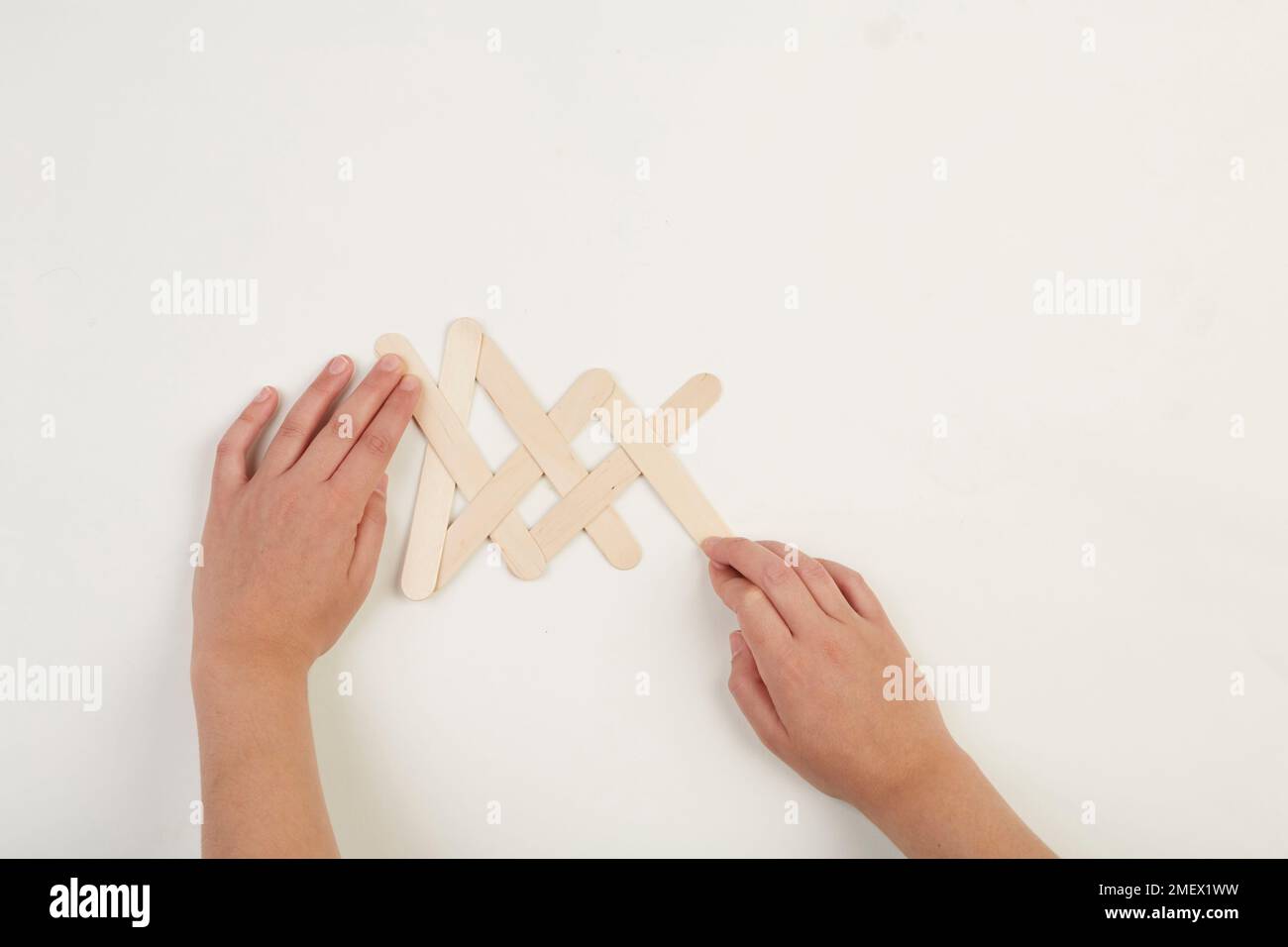 Creating stick bomb patterns out of popsicle sticks Stock Photo - Alamy