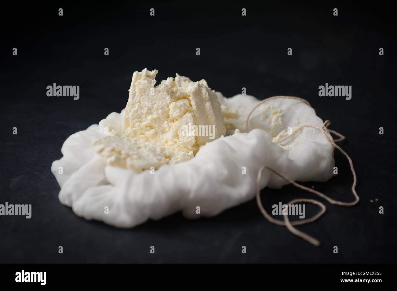 Making cheese, step 3: finished cheese in muslin bag, partially ...