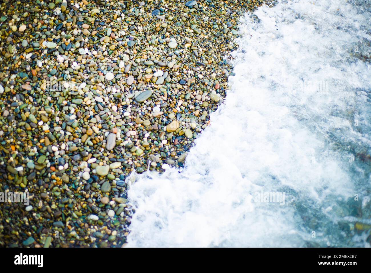 Sea foam on a pebble beach. close-up. Marine textures and backgrounds ...